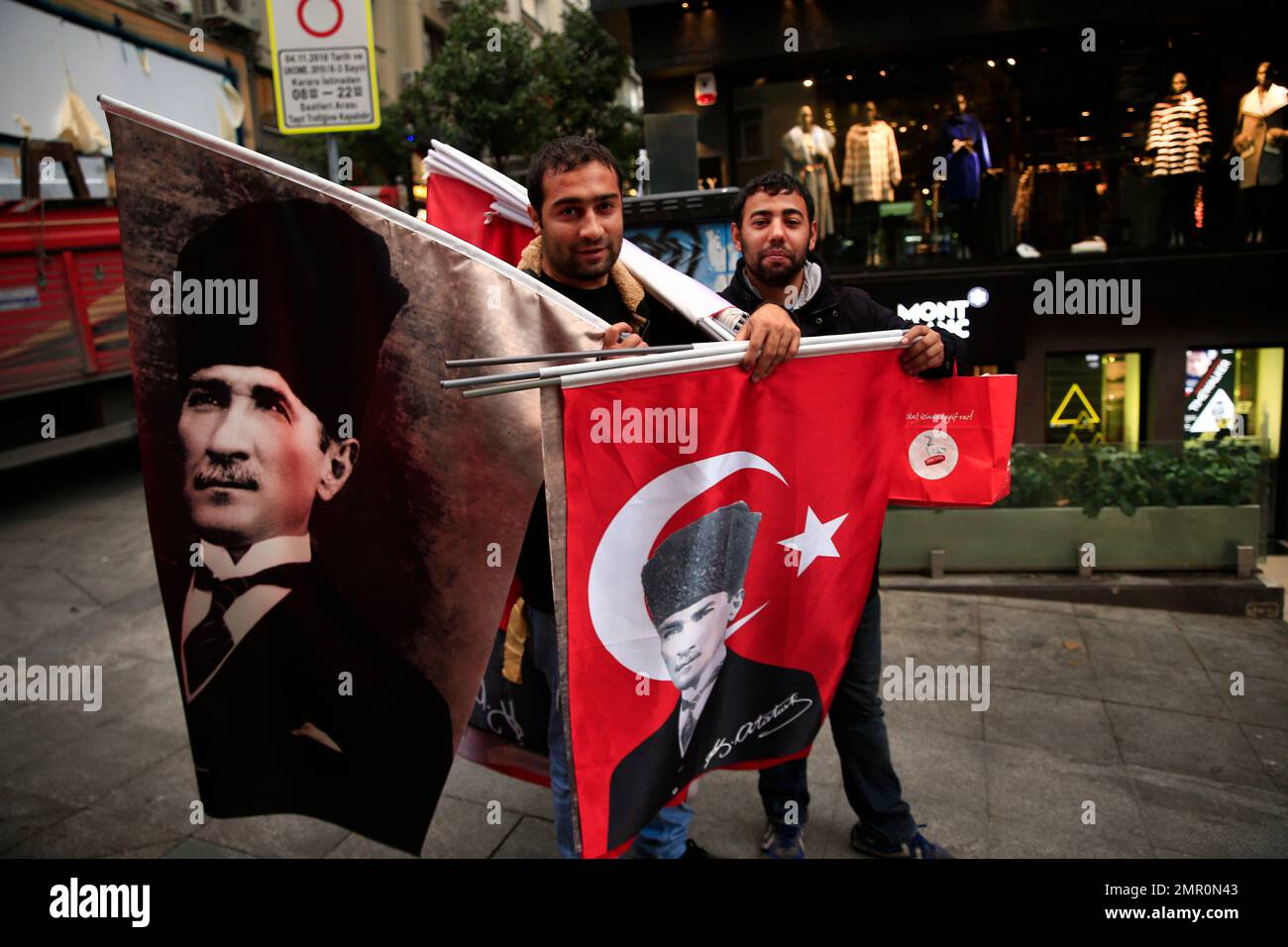 A vendor carrying flags with pictures of Turkey's founding father ...