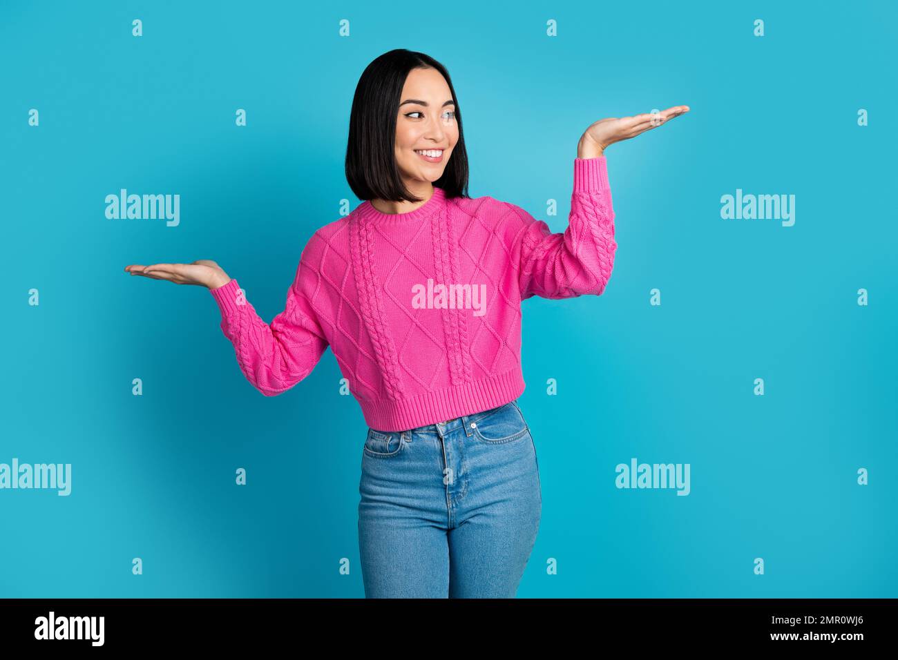 Portrait of pretty indonesian girl look arms hold compare evaluate two ...