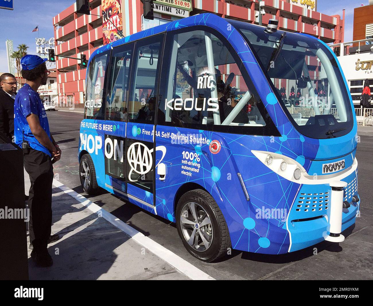 Patrons wait to board a driverless shuttle bus on a street in Las Vegas ...