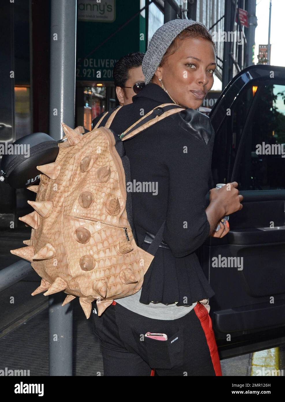 Wearing a grey stocking cap paired with a black jacket, grey top and ...