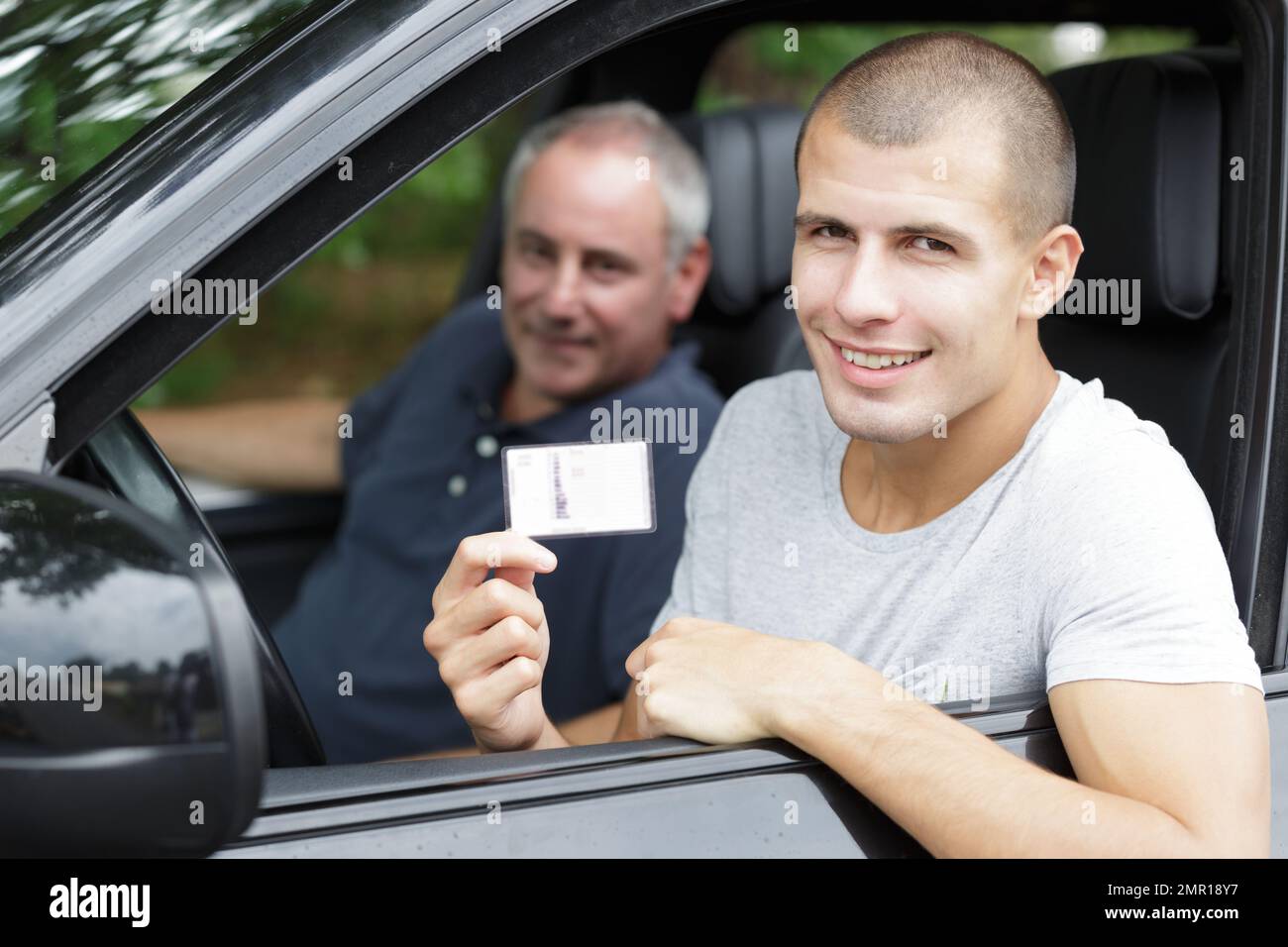 happy young successful man showing his new european driving license ...