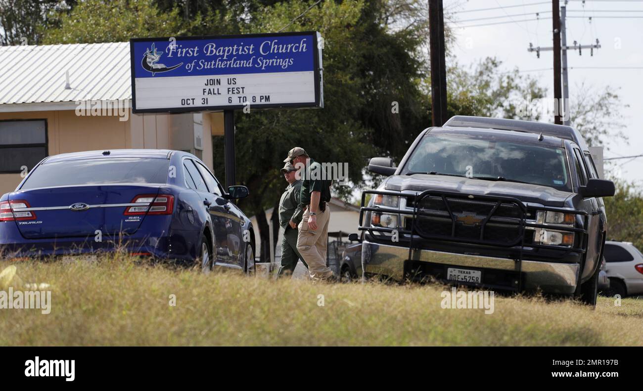 Law enforcement officials continue to investigate the scene of a ...
