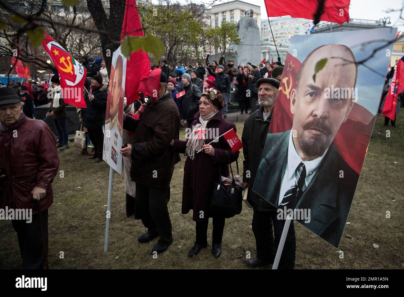 Communist party supporters stand next to a monument to Karl Marx ...