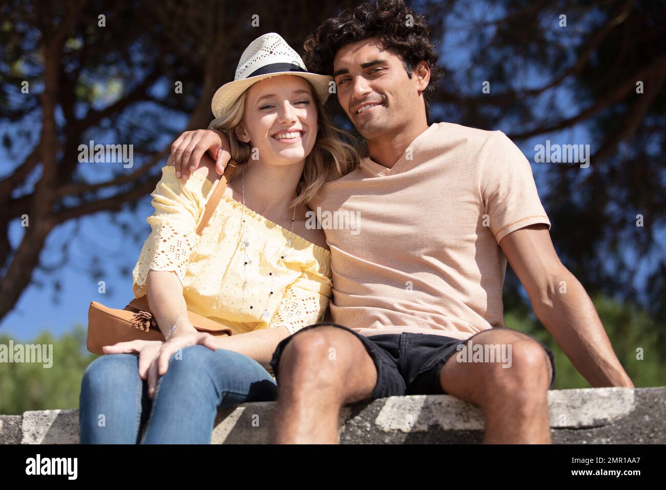 romantic couple sit on a wall Stock Photo - Alamy