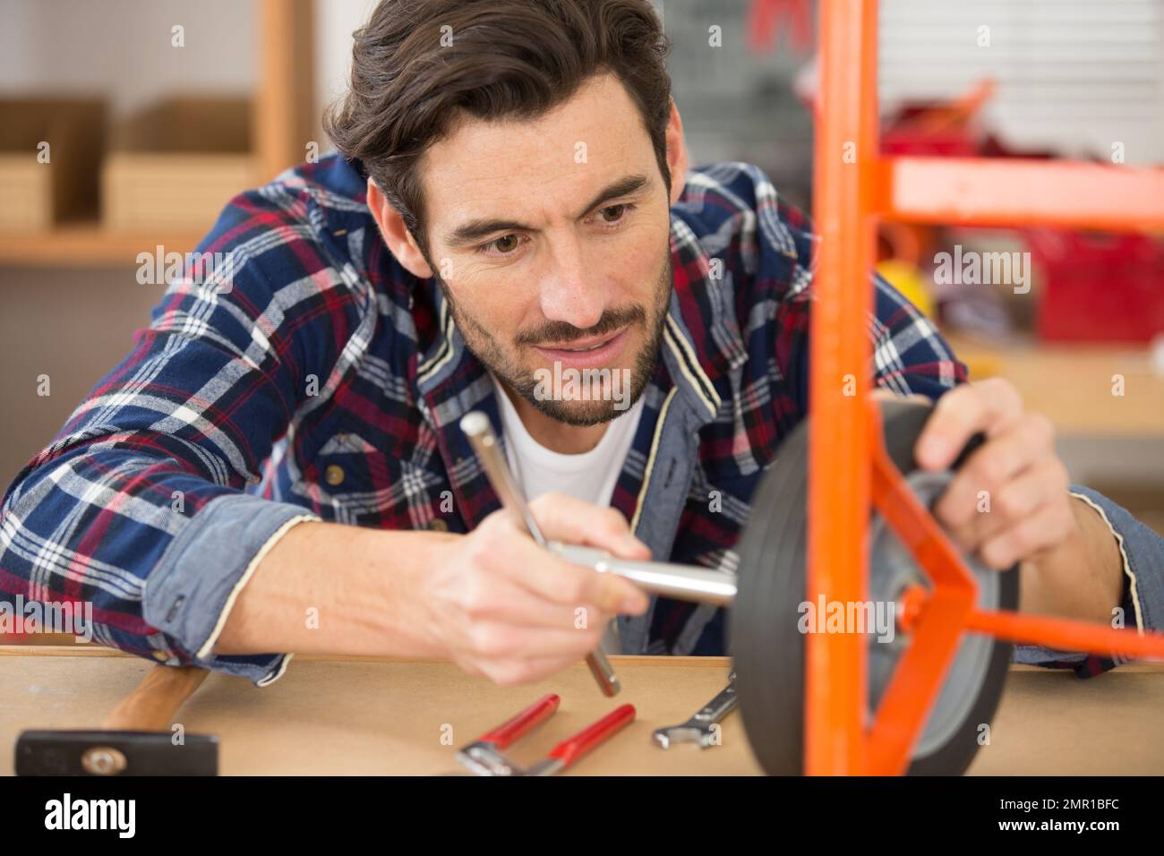man fixing a trolley wheel Stock Photo - Alamy
