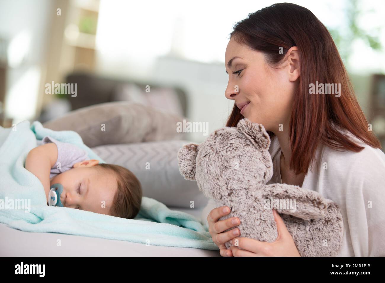 warm moment of mother cradling her newborn sleeping baby Stock Photo ...