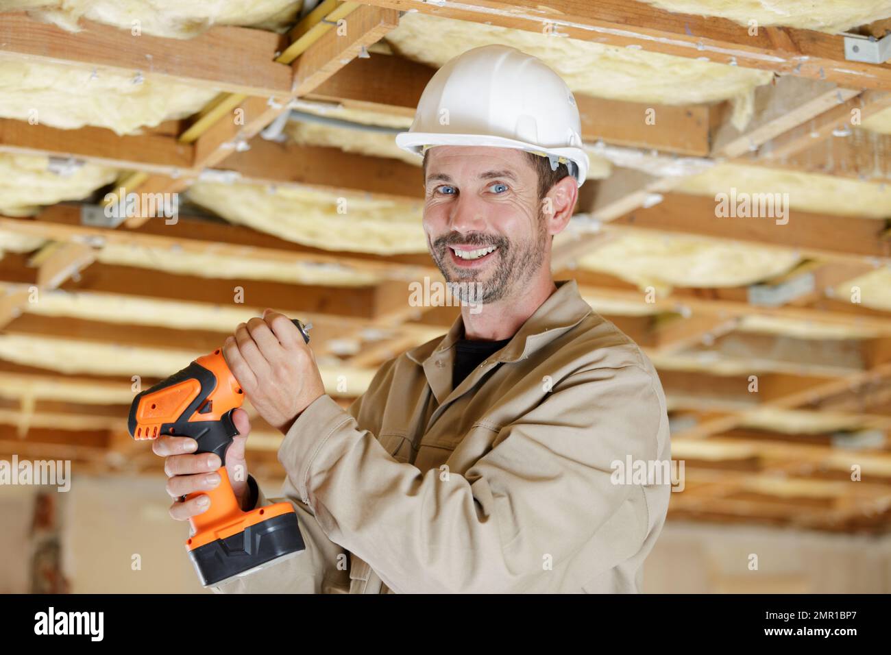 mid-adult man drilling hole in wall Stock Photo - Alamy