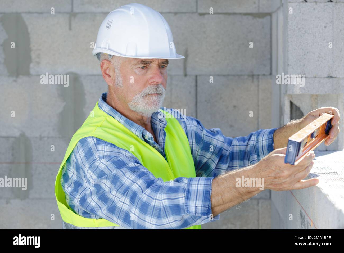 senior builder measures a wall Stock Photo - Alamy