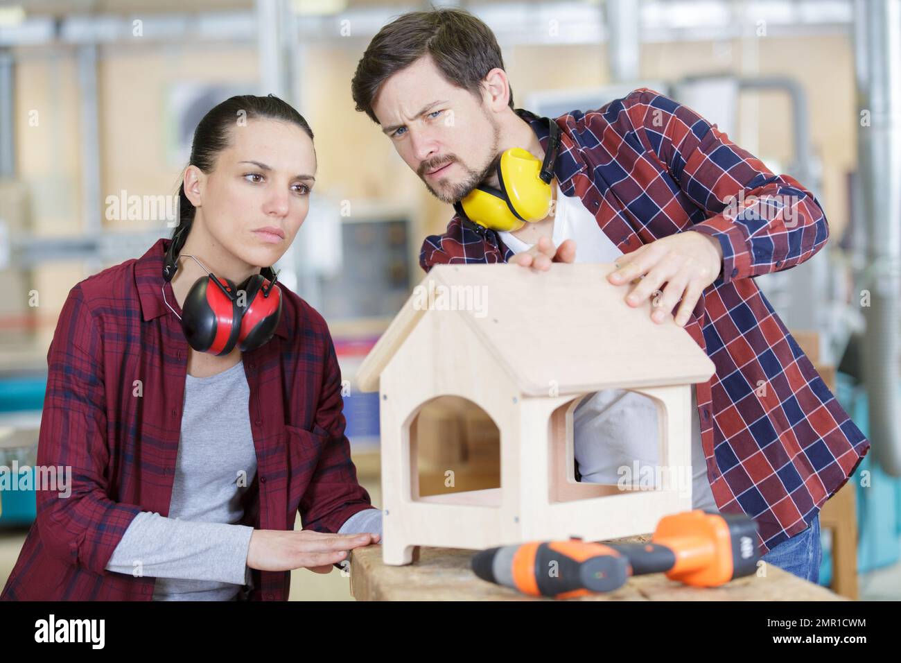 man and woman are making a small house from wood Stock Photo - Alamy