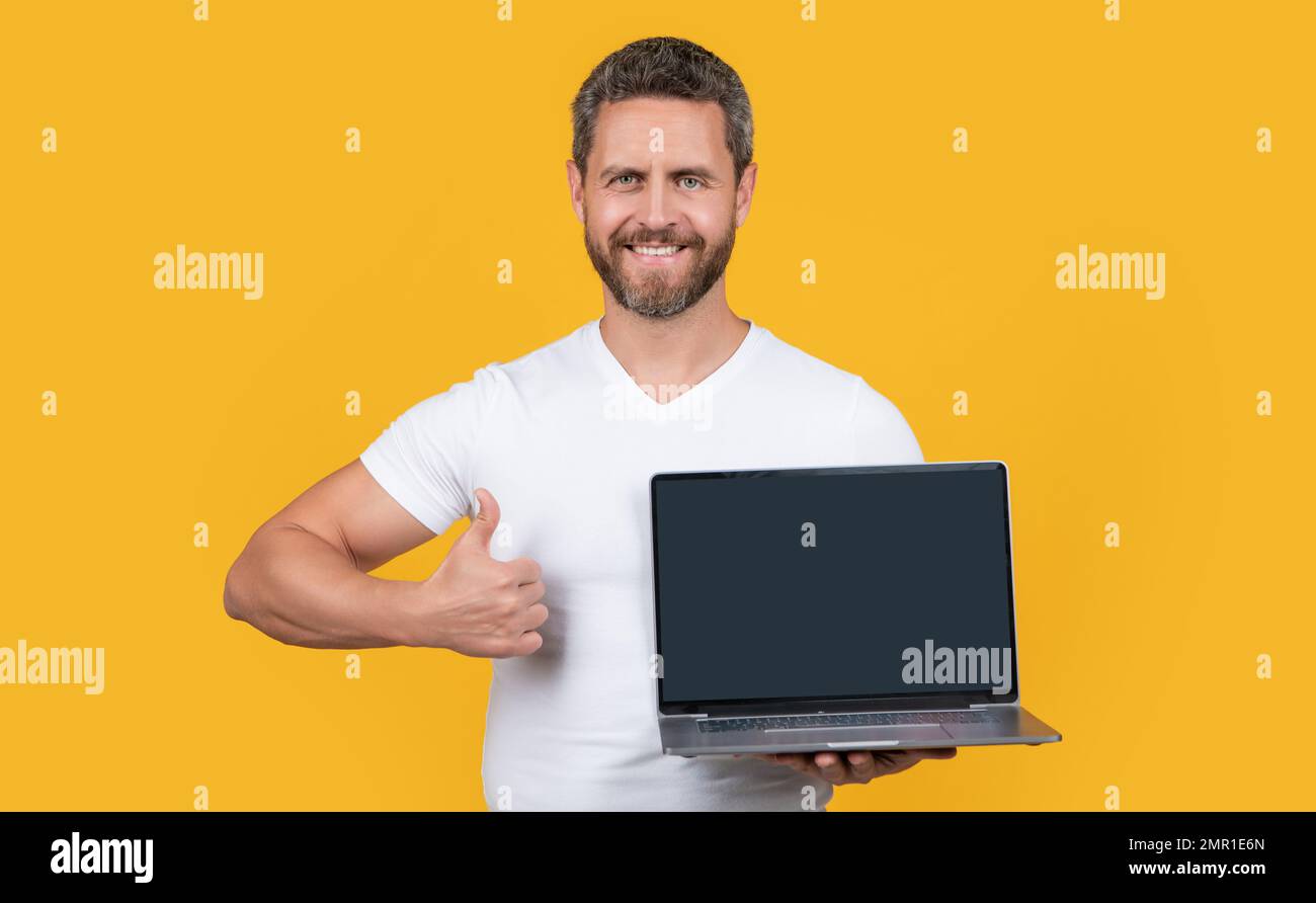 man showing screen in studio, thumb up. man showing screen of laptop ...