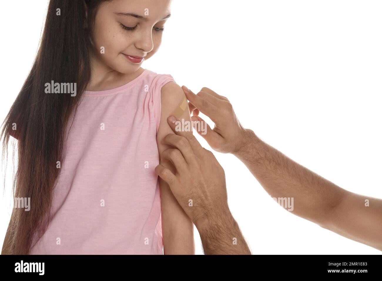 Man putting sticking plaster onto girl's arm on white background Stock ...