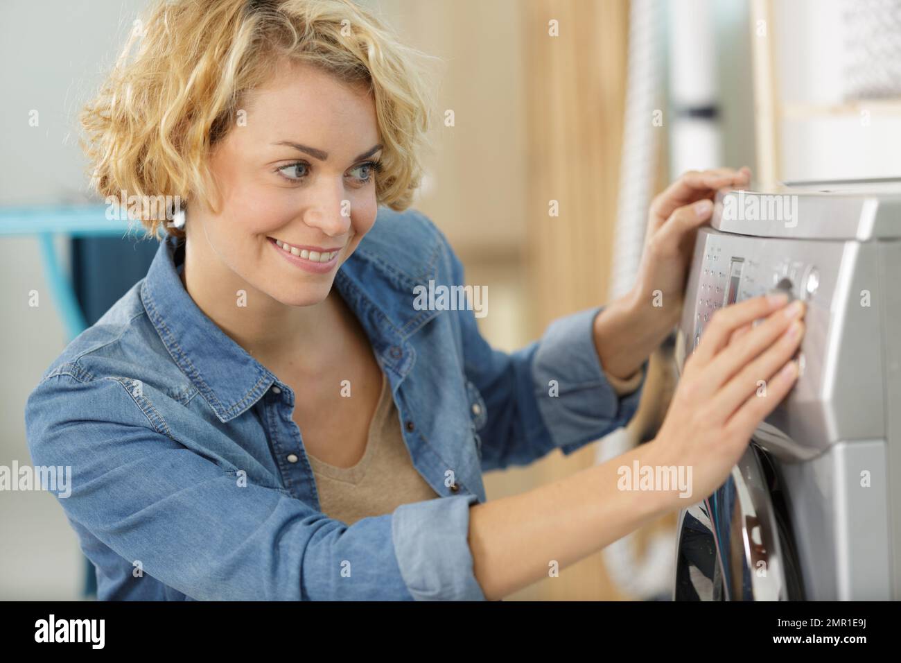 woman presses a button on the washing machine Stock Photo - Alamy