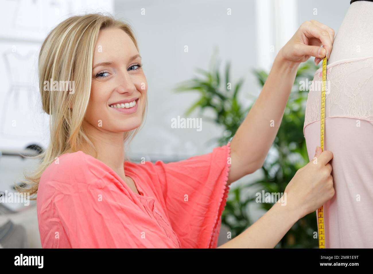 young fashion designer measuring garment on mannequin Stock Photo - Alamy