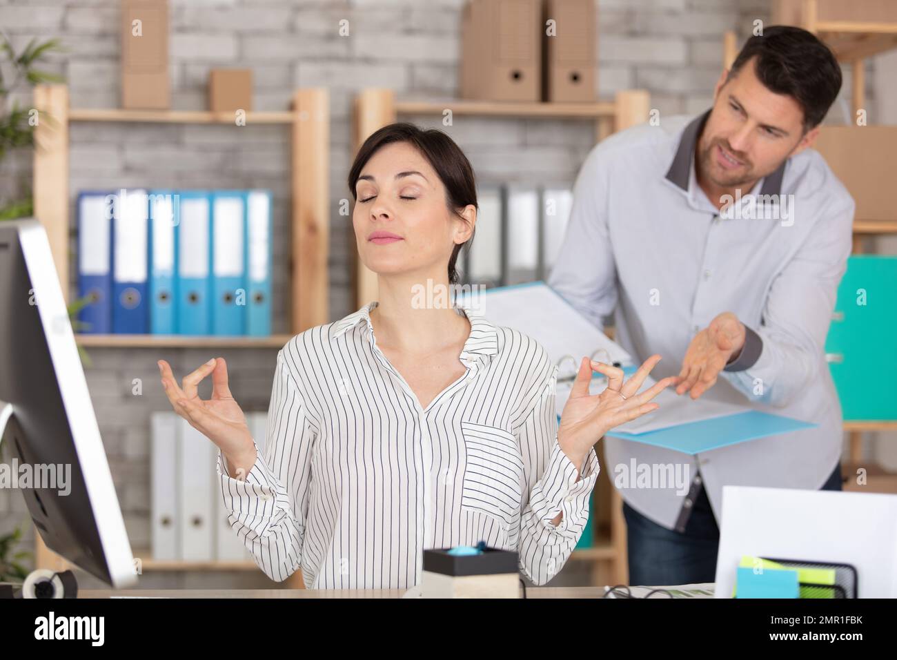 calm young woman doing yoga exercise at workplace Stock Photo - Alamy