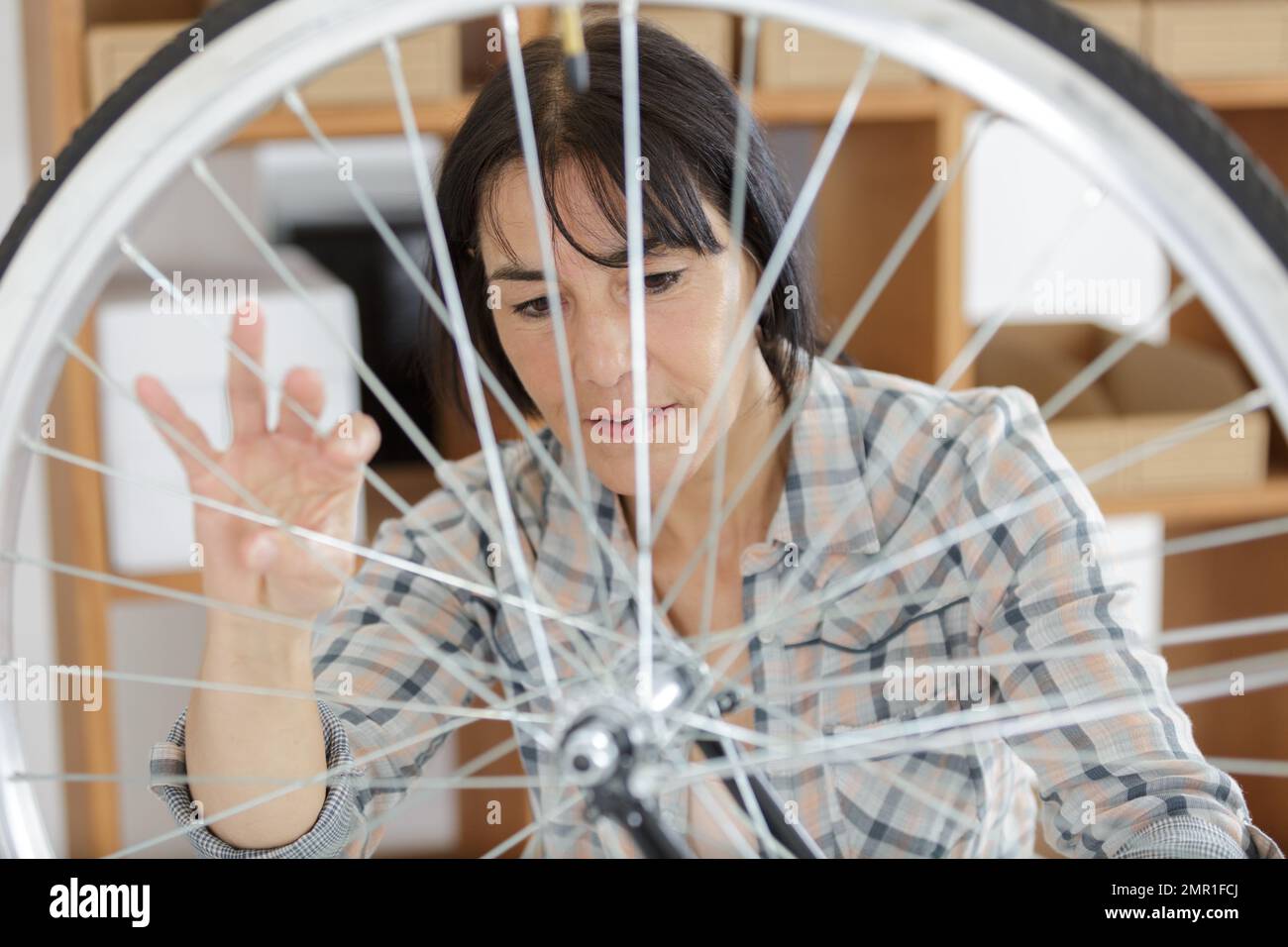 mature woman fixing wheels in workshop Stock Photo - Alamy