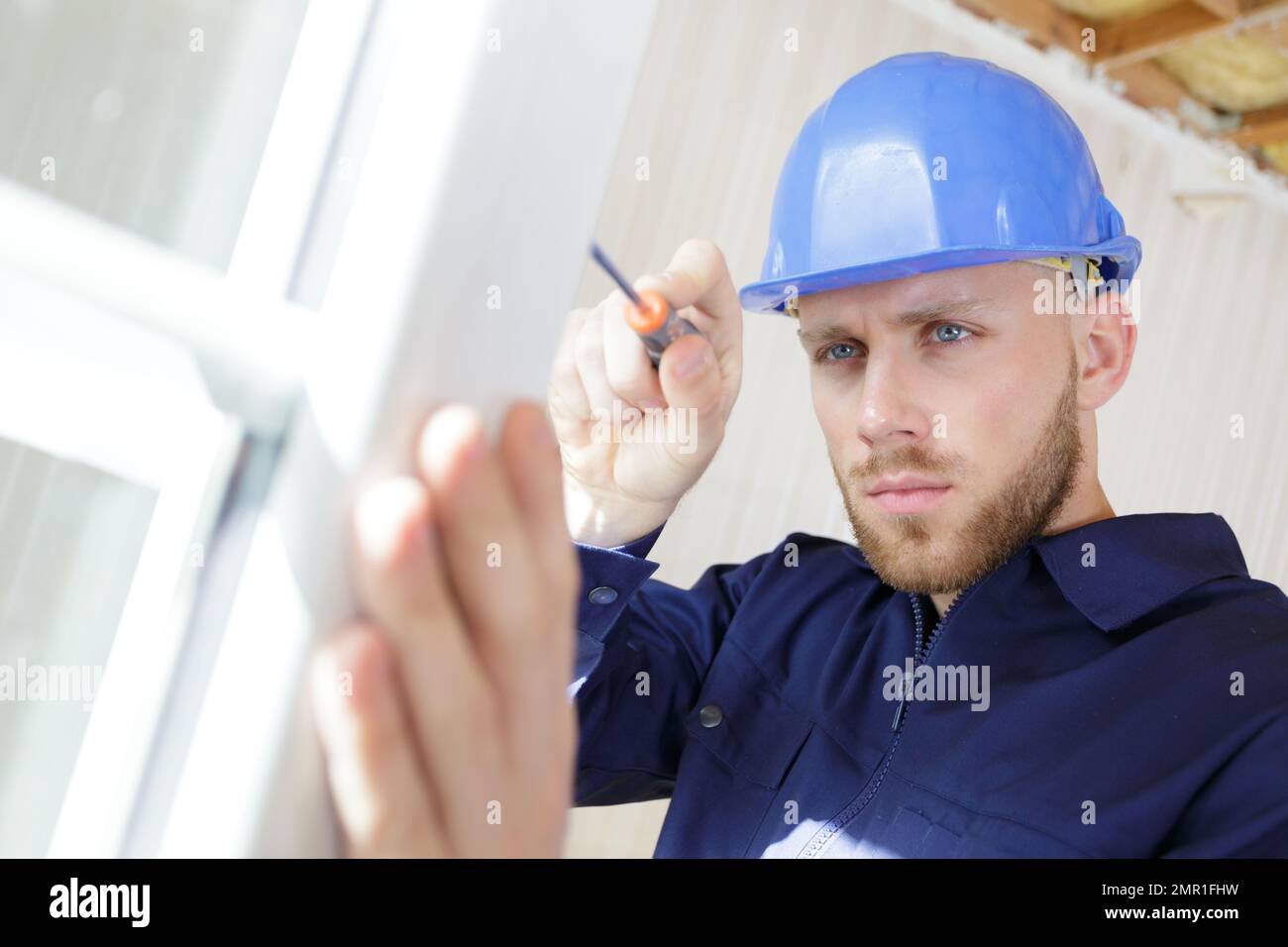 young worker screws screw with a screwdriver Stock Photo - Alamy