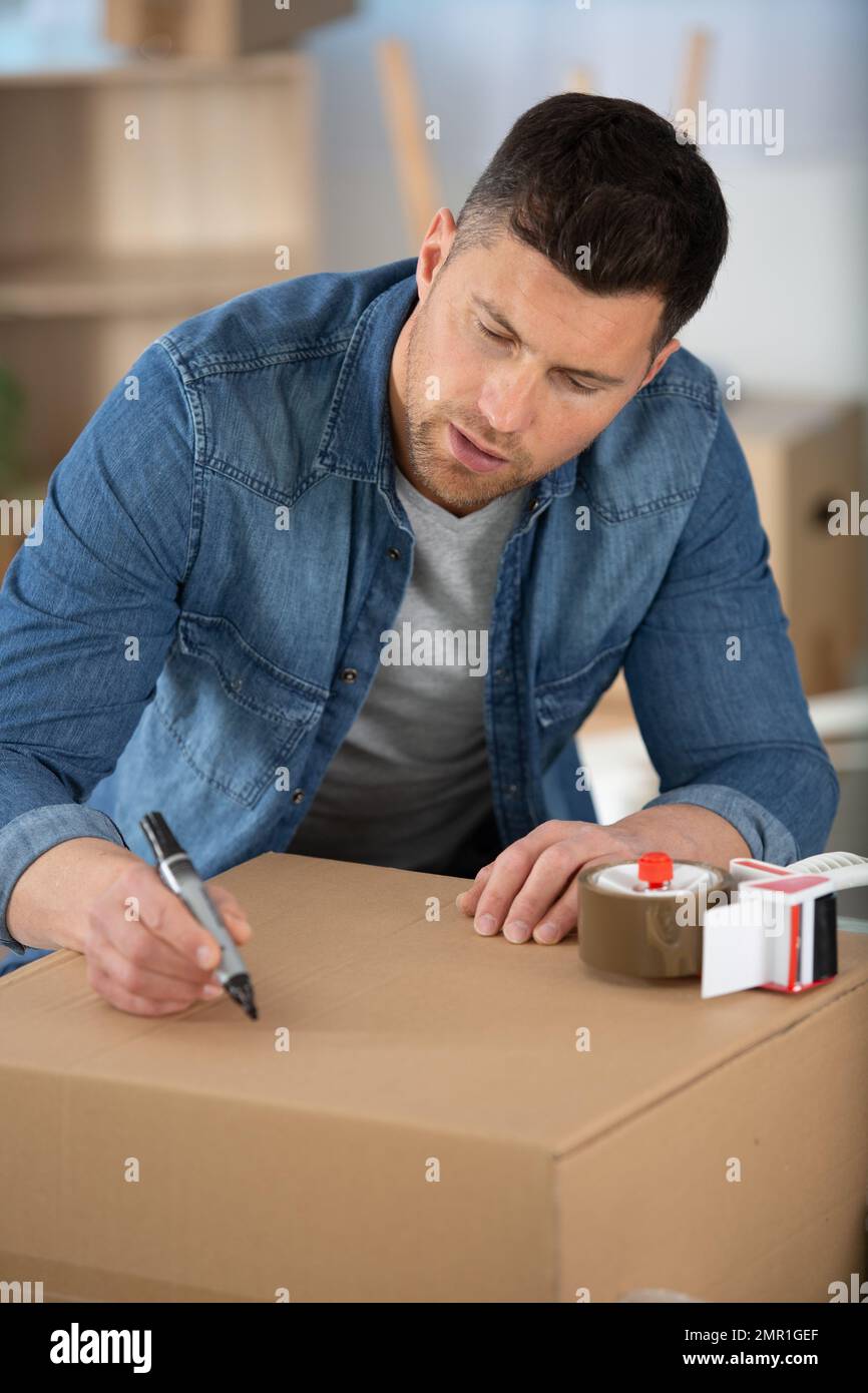 man writing on cardboard box Stock Photo - Alamy