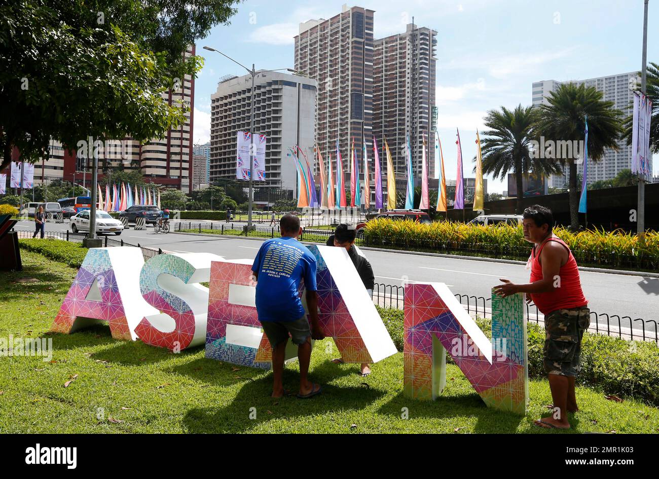 Workers try to arrange block letters of "ASEAN" prior to setting them ...