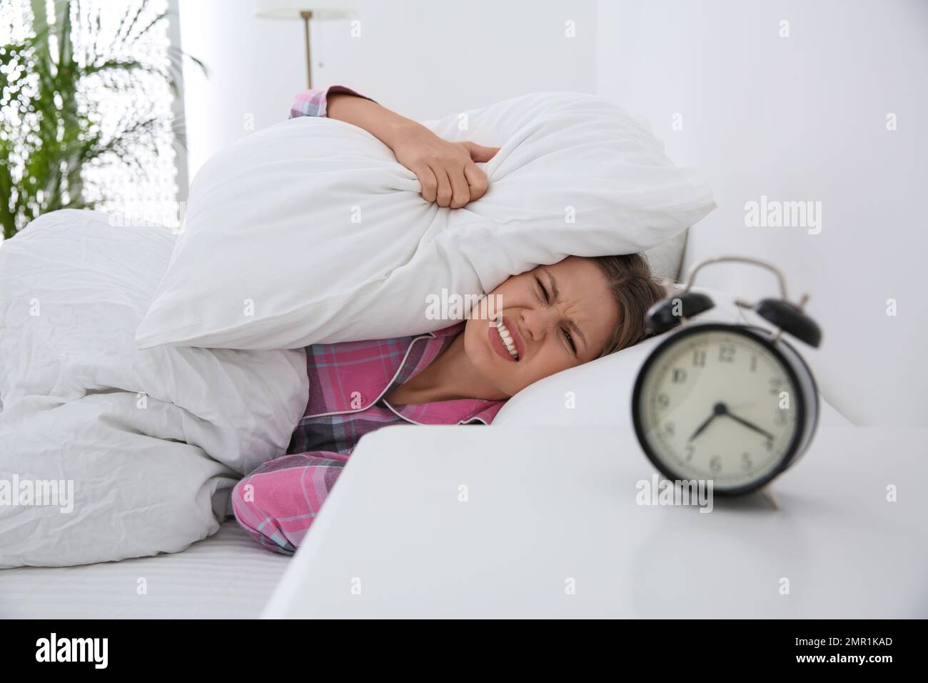 Woman covering ears alarm clock hi-res stock photography and images - Alamy