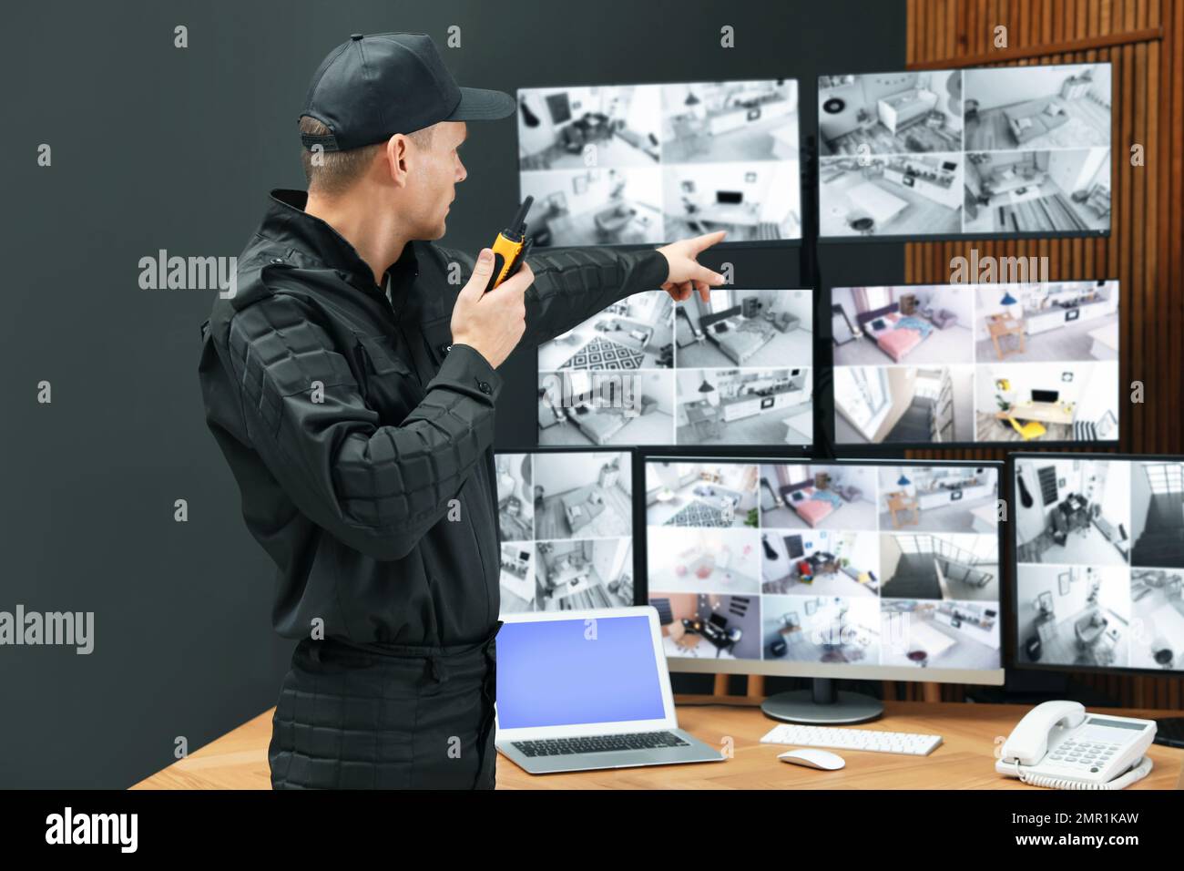 Security guard with portable transmitter monitoring modern CCTV cameras ...