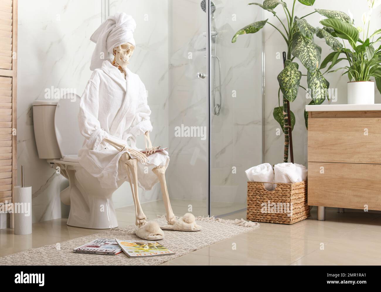 Skeleton in bathrobe with mobile phone sitting on toilet bowl Stock ...