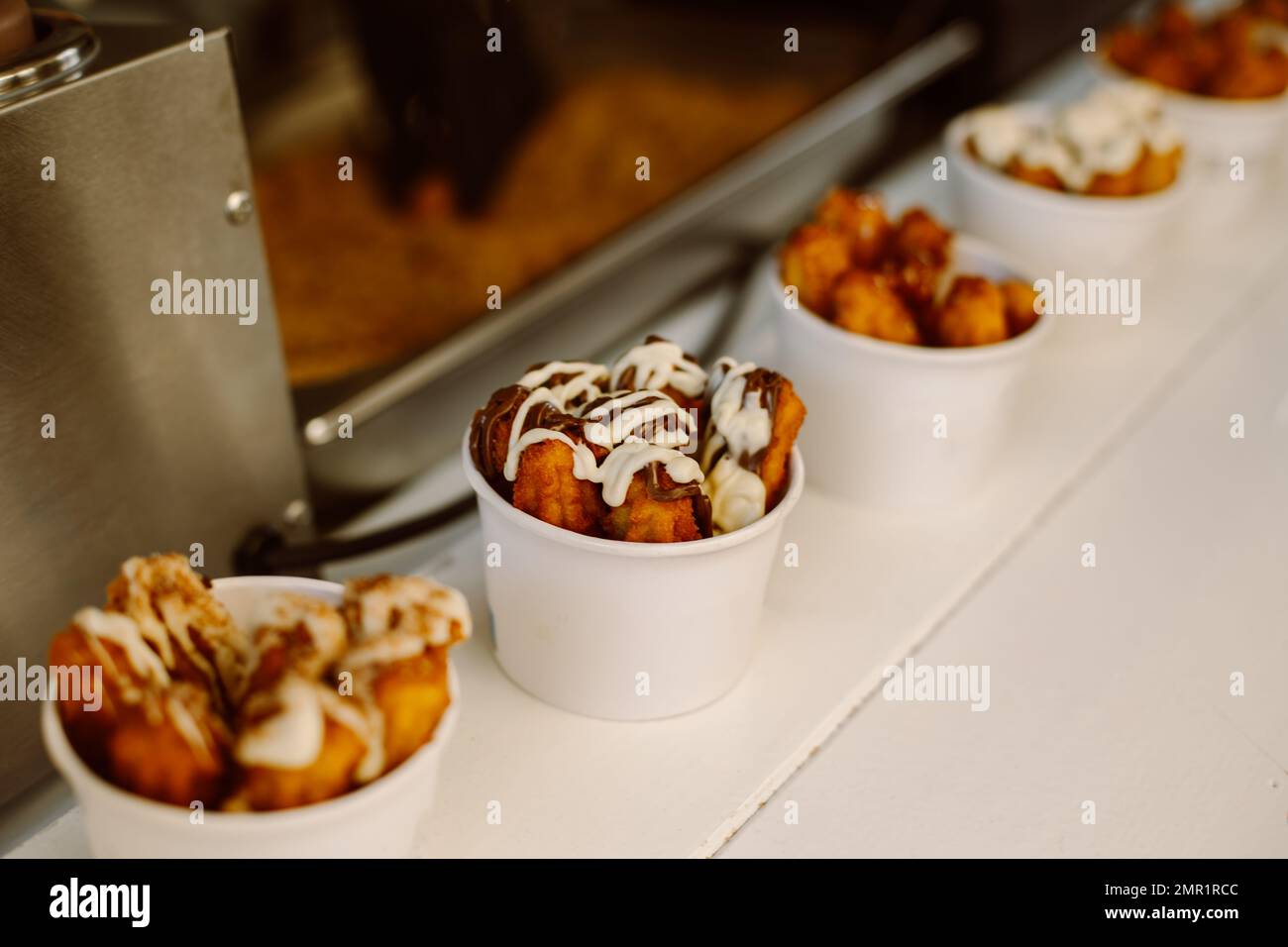 Delicious churros sticks with cream and chocolate in a street cafe ...