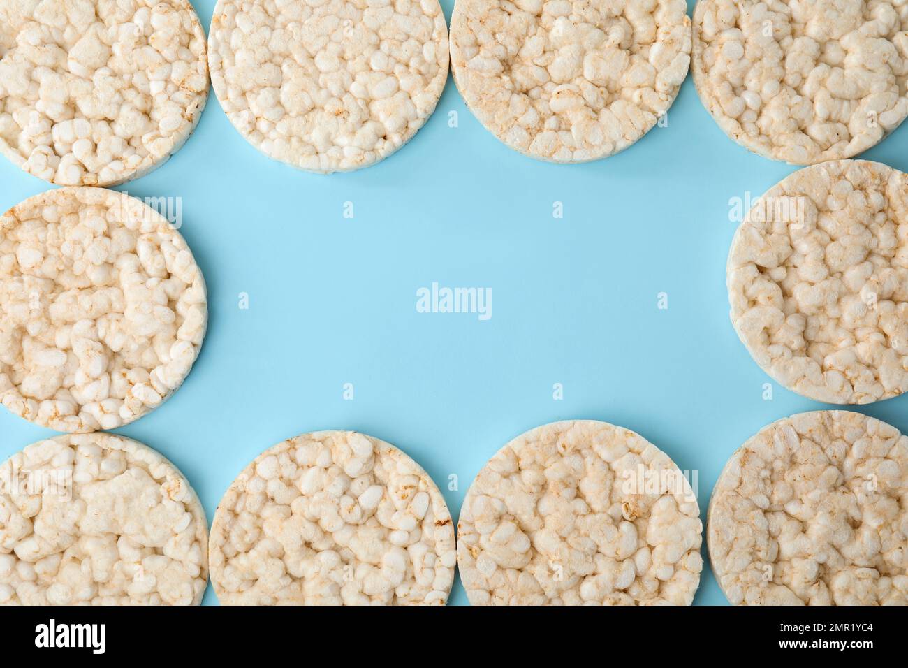 Frame made of puffed rice cakes on light blue background, flat lay ...