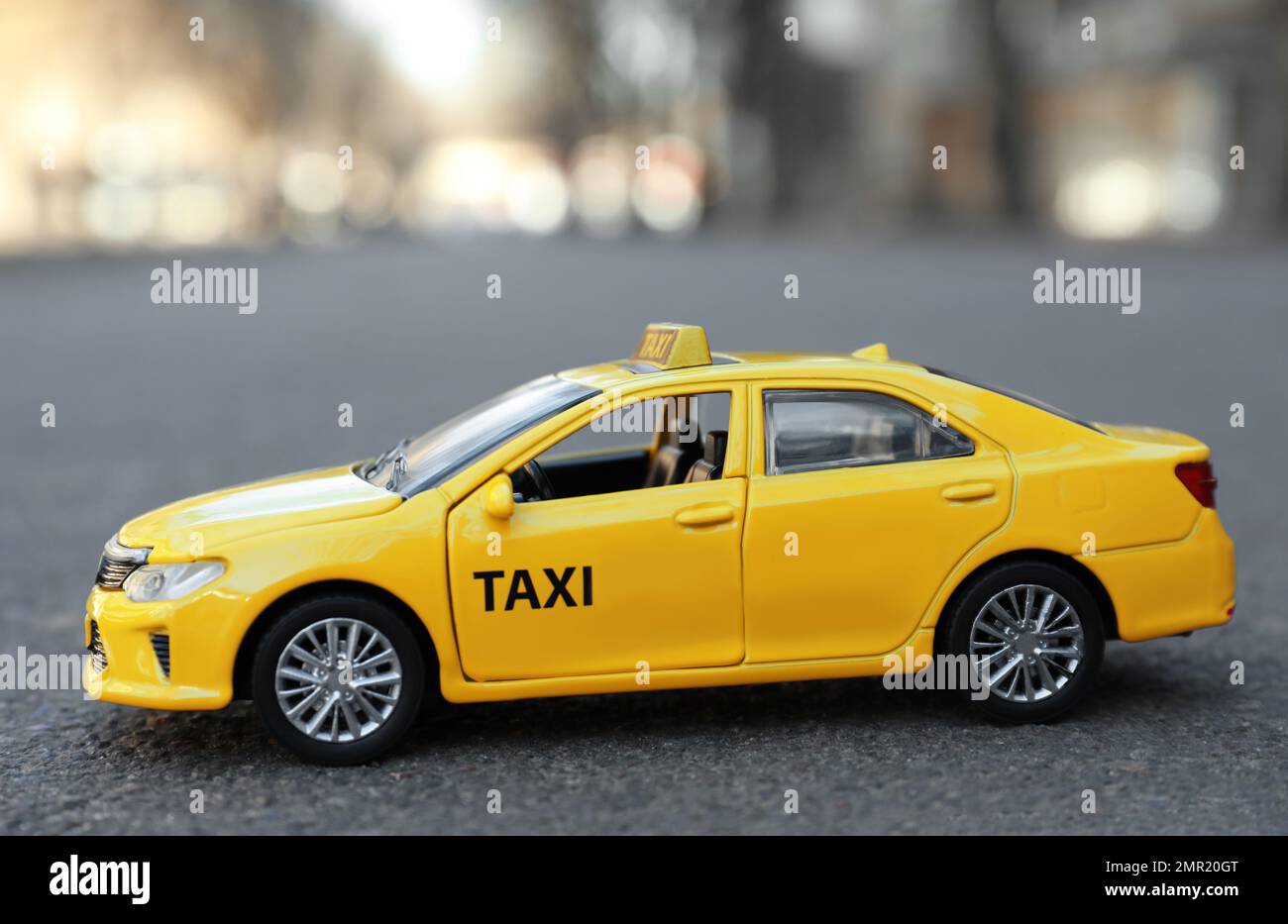 Yellow taxi car model on city street Stock Photo - Alamy