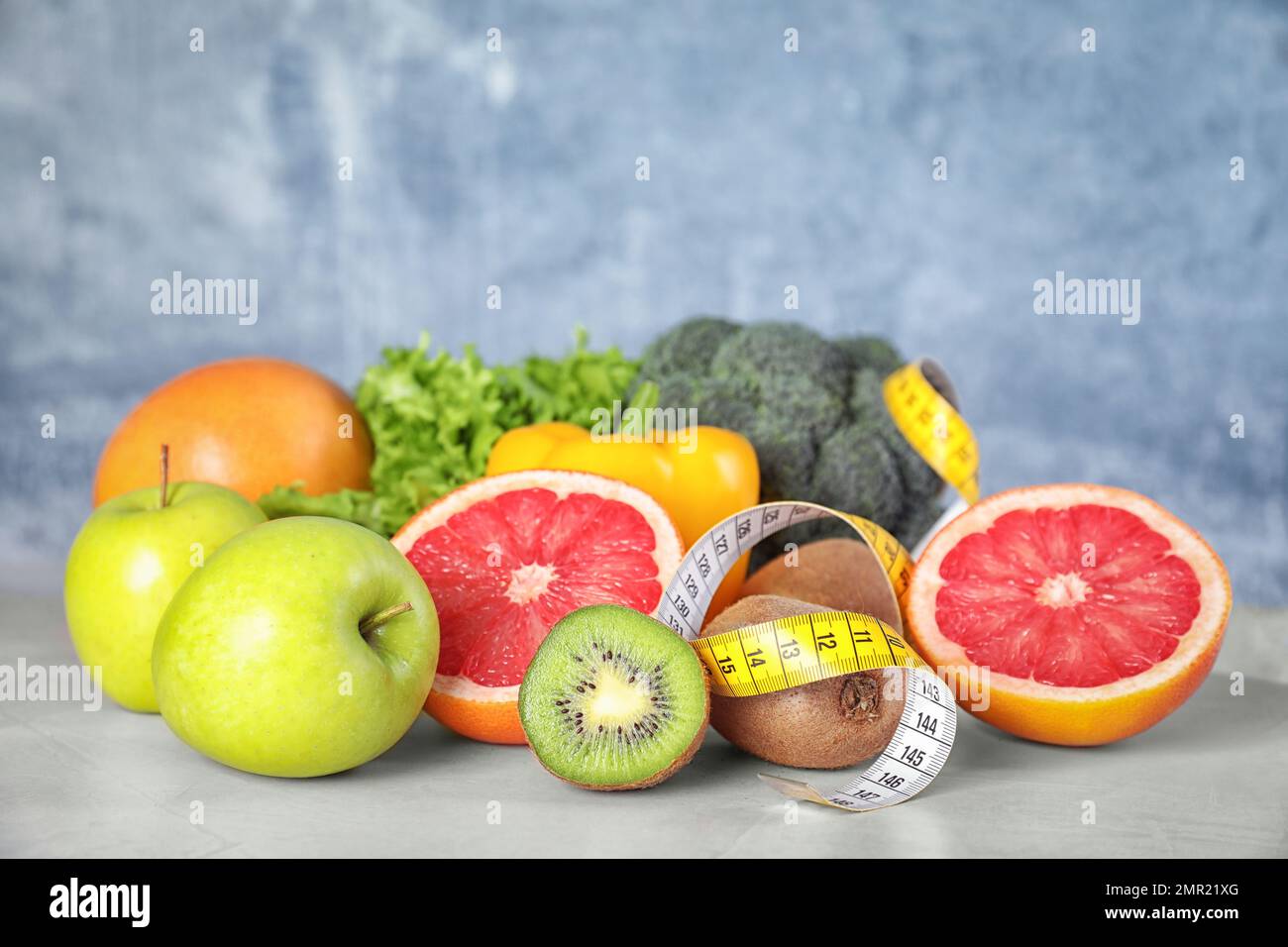 Measuring tape, vegetables and fruits on table. Diet plan from ...