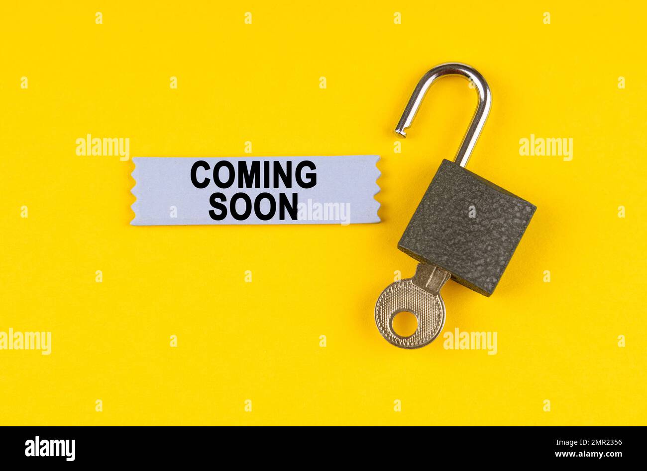 On the yellow surface lies an open lock with a key, next to it is a ...