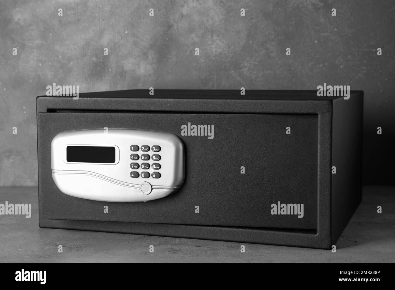 Black steel safe with electronic lock on grey table Stock Photo - Alamy