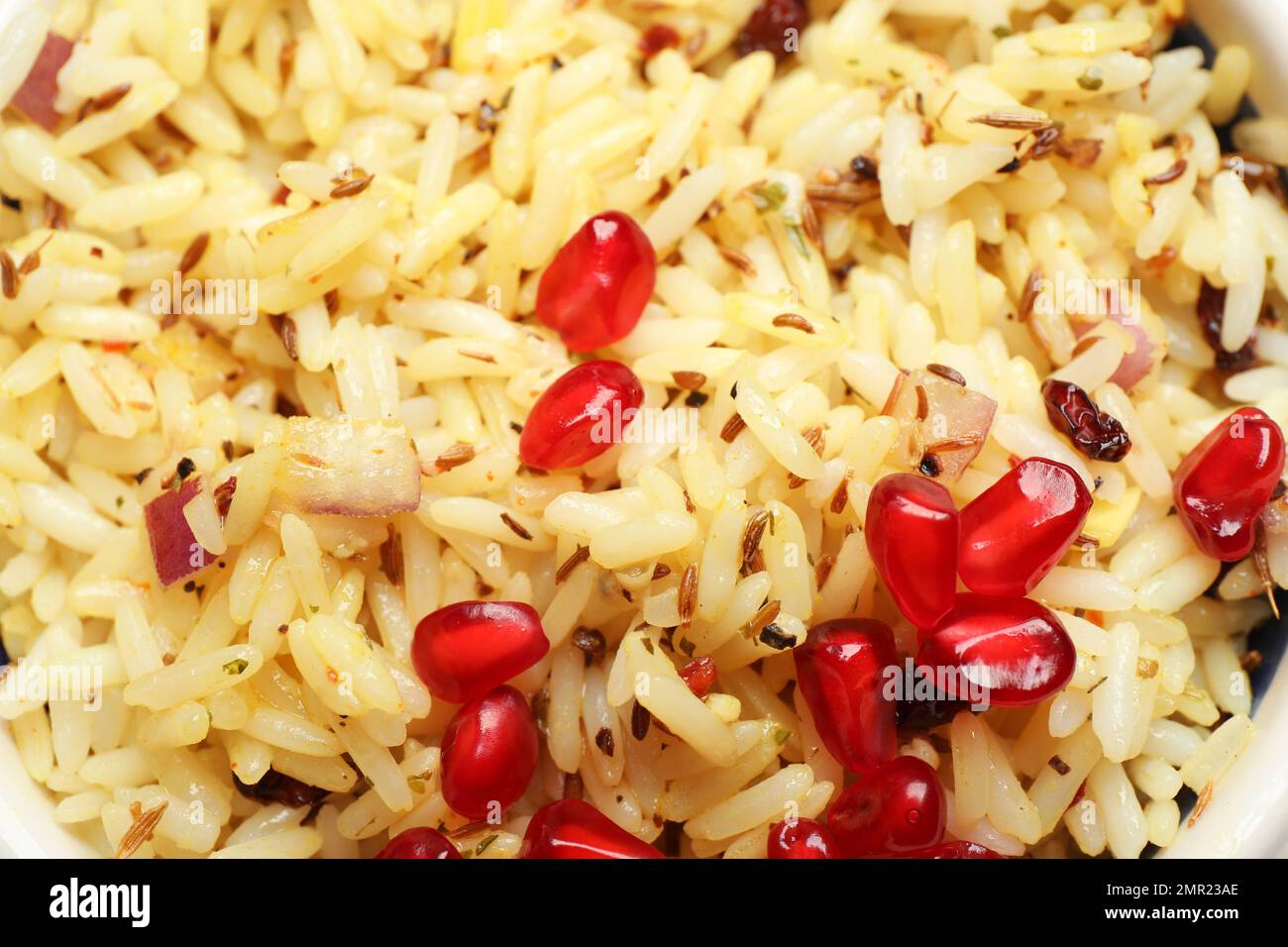 Tasty rice pilaf with pomegranate grains as background closeup Stock ...