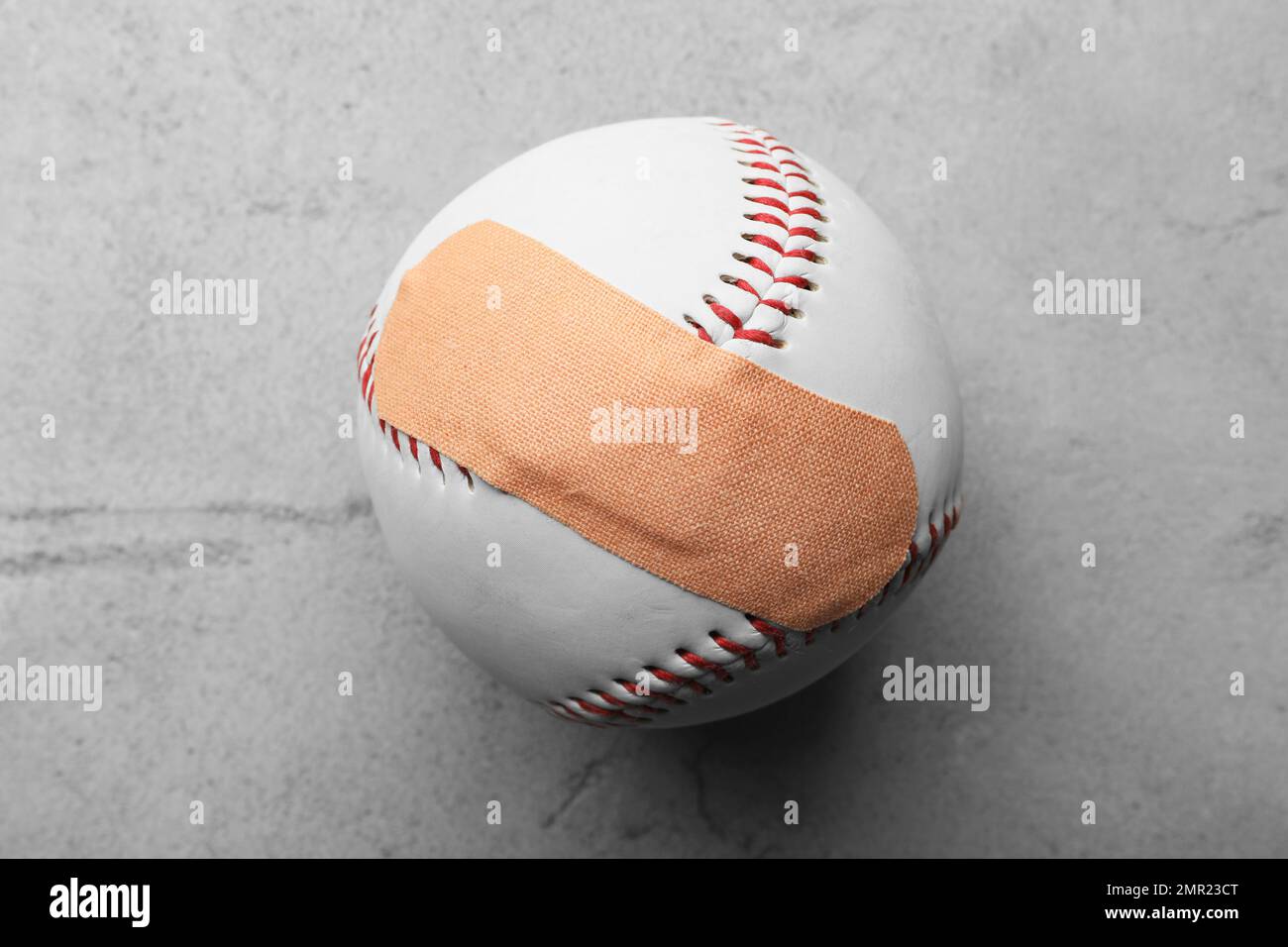 Ball with sticking plaster on light grey stone table, top view Stock ...
