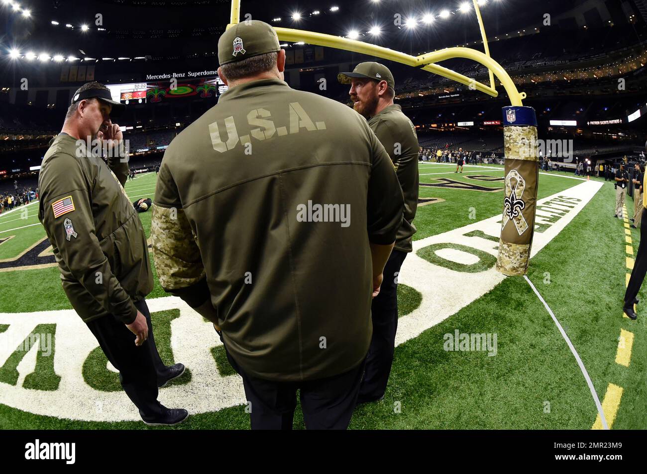 Team personnel wear Salute To Service clothing and stand amongst ...