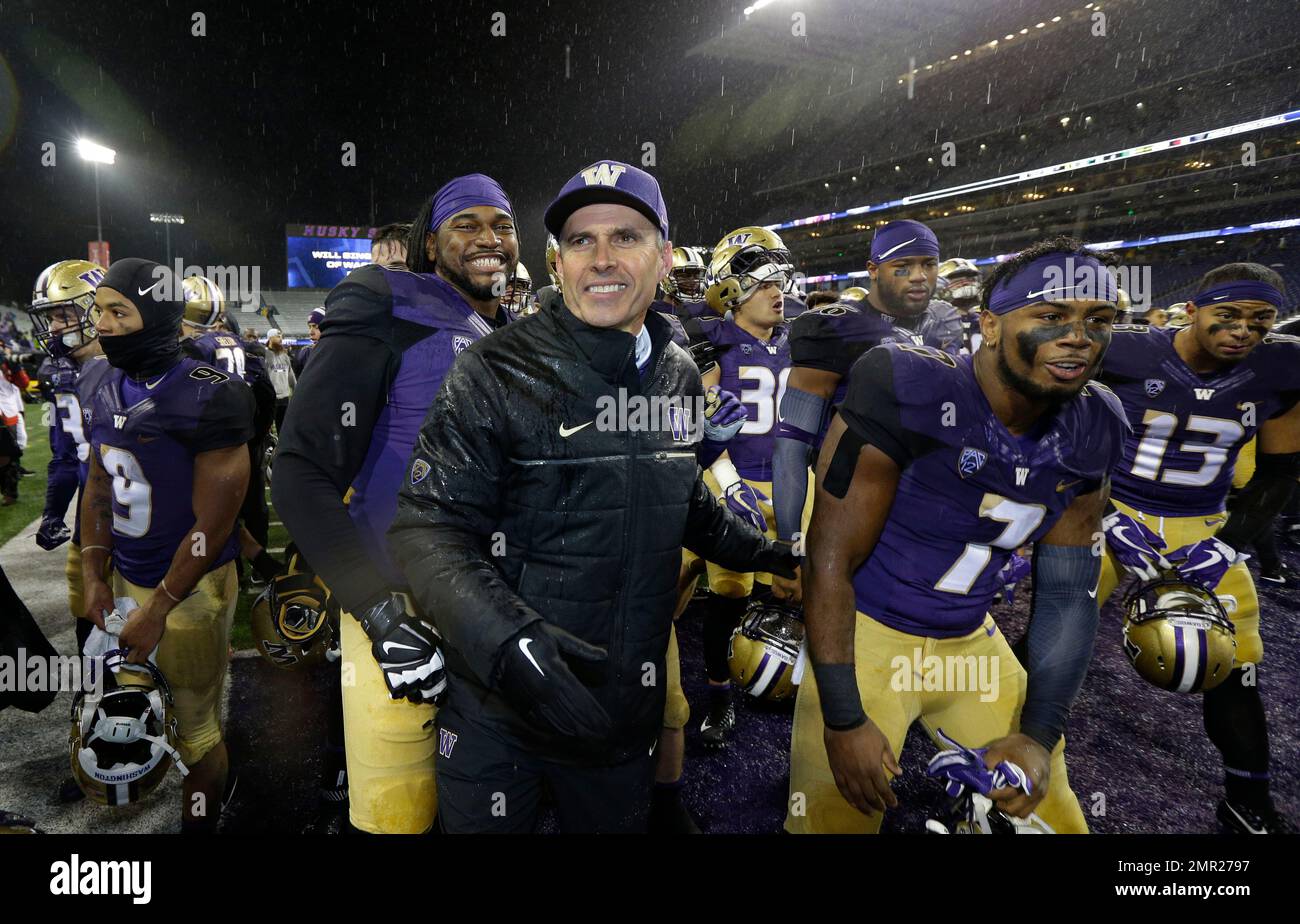 Washington head coach Chris Petersen, center, leads his team off the ...