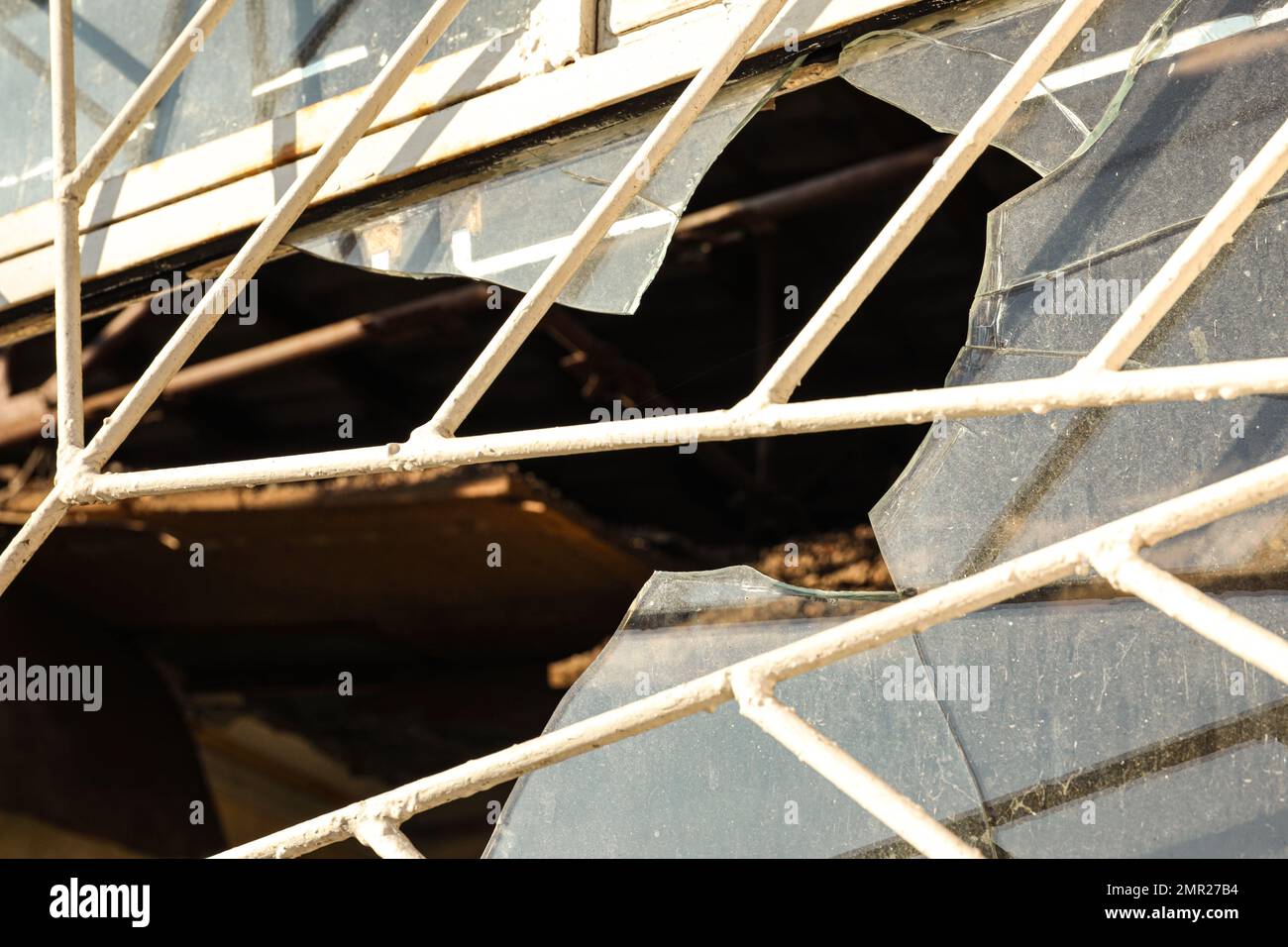 Broken window with metal grid outdoors. Requiring repair Stock Photo ...