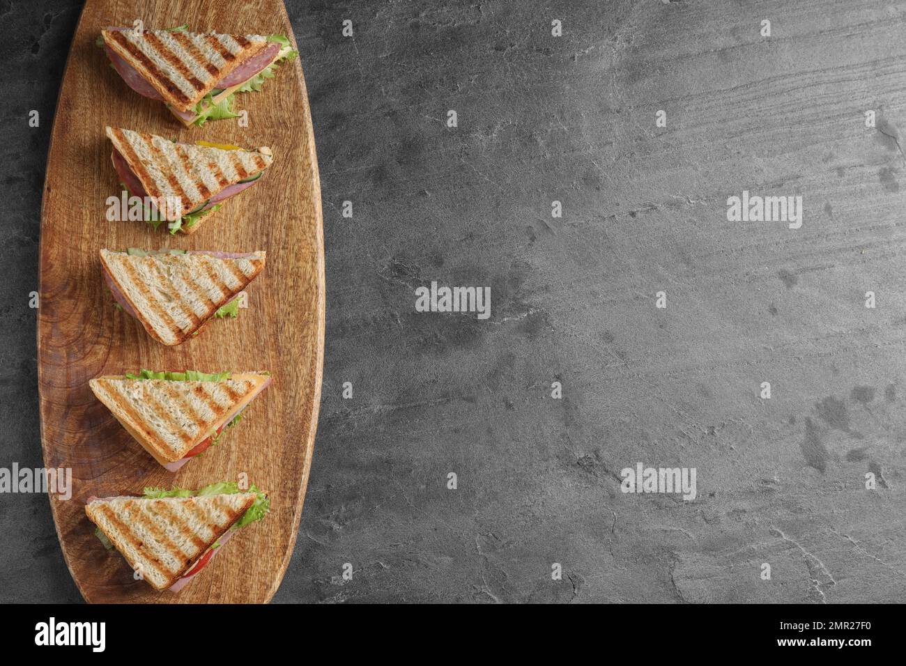Tasty sandwiches with ham on grey table, top view. Space for text Stock ...