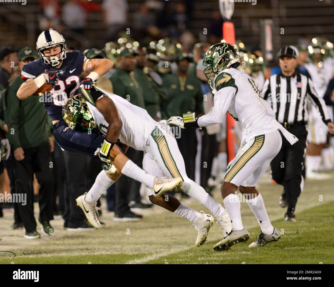 Connecticut wide receiver Mason Donaldson (82) is shoved out of bounds by South Florida safety ...