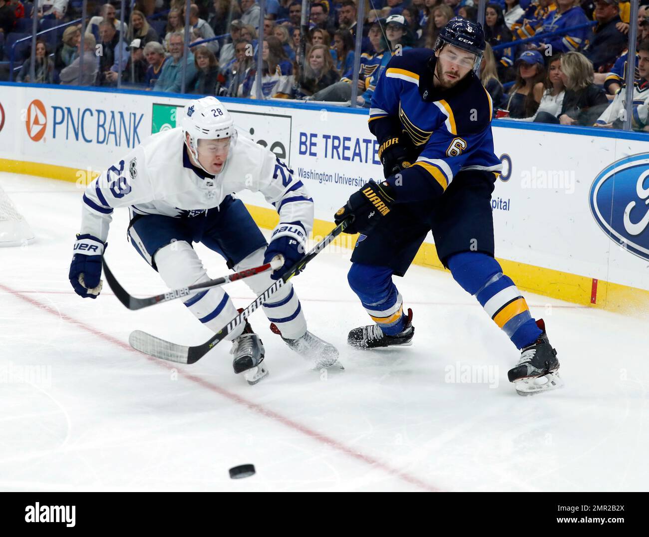 St. Louis Blues' Joel Edmundson (6) passes around Toronto Maple Leafs ...