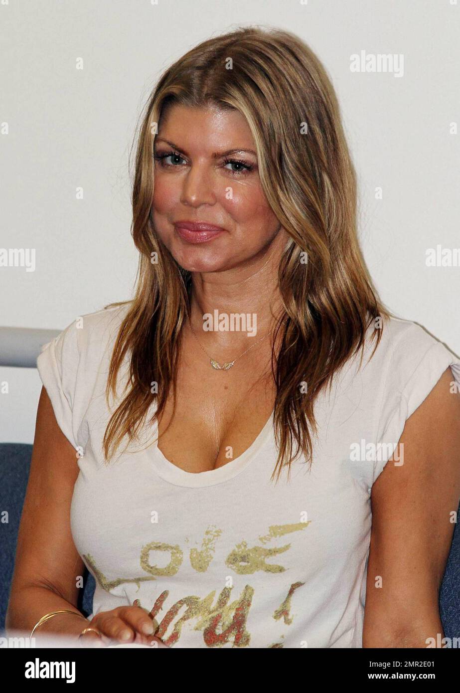 Singer Fergie keeps it casual in a v-neck top that says 'Love You' and ...