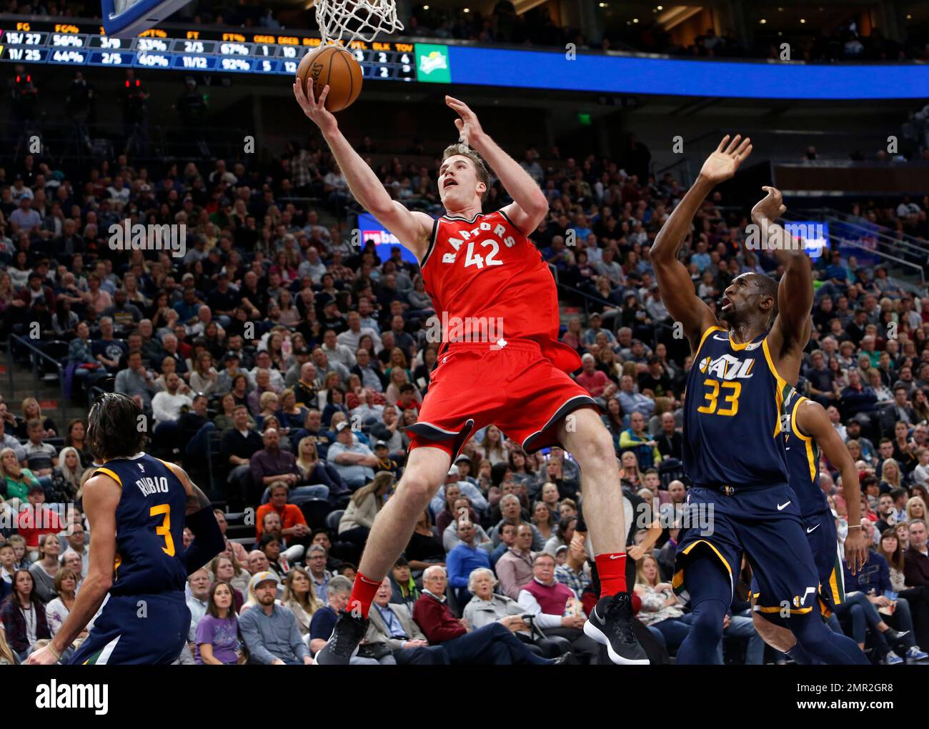 Toronto Raptors' Jakob Poeltl (42) attempts a layup over the heads of ...