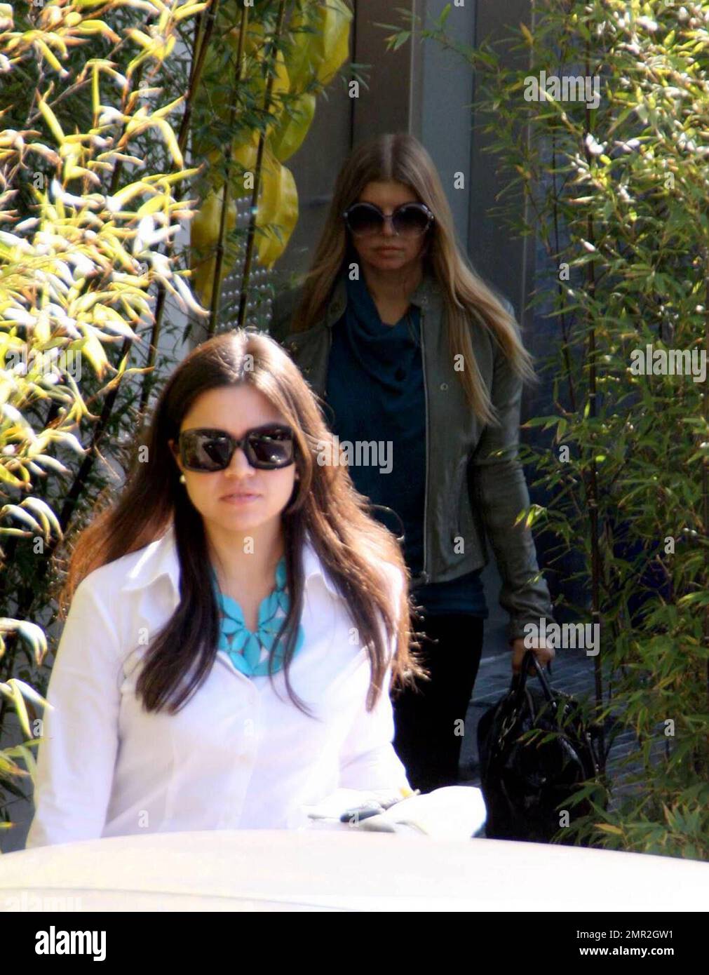 Singer Fergie and an assistant leave Fergie's Los Angeles home. Perhaps ...