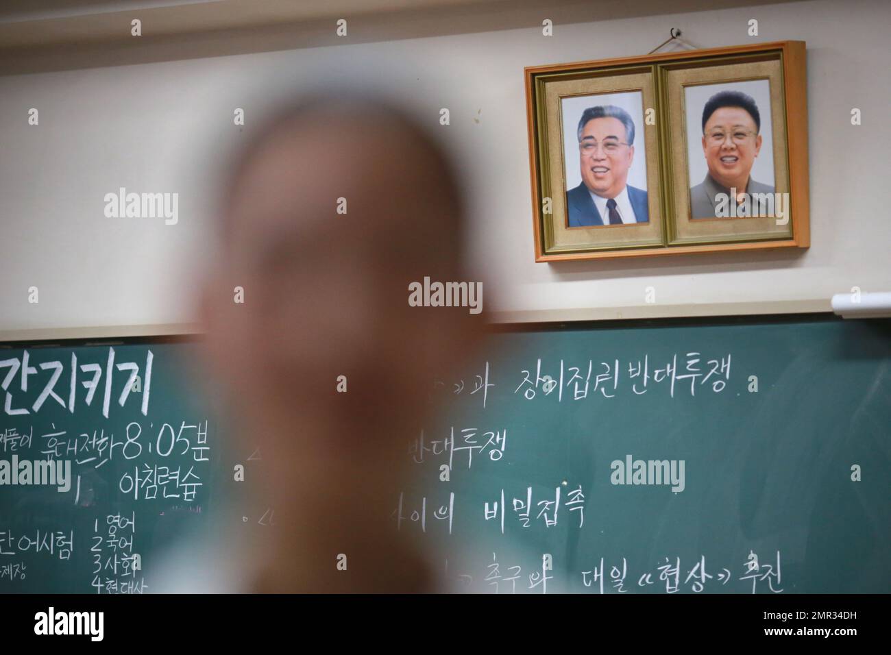 In this Sept. 26, 2017, photo, a student stands near the portraits of ...