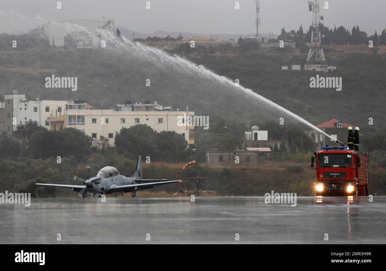 A fire truck sprays water on a Super Tucano A29 warplane, at Hamat ...