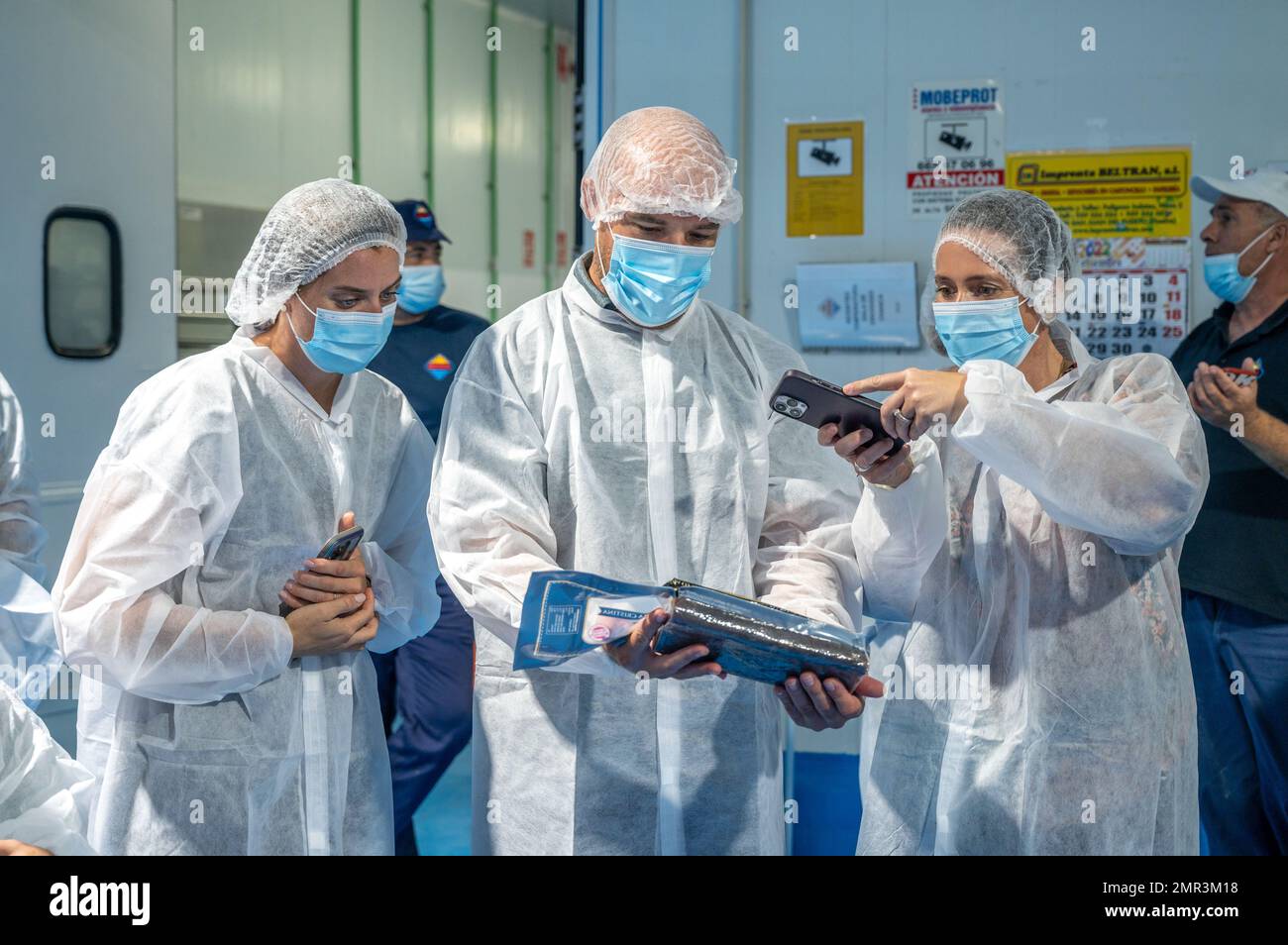 People in PPE looking at packaged products, Fish canning factory (USISA ...