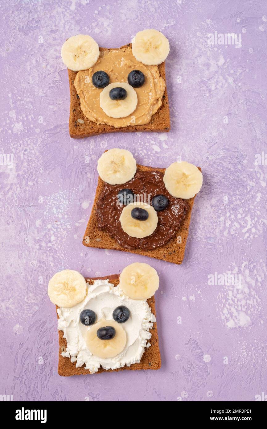 Breakfast toasts with nut butter and banana with cute funny bear face ...