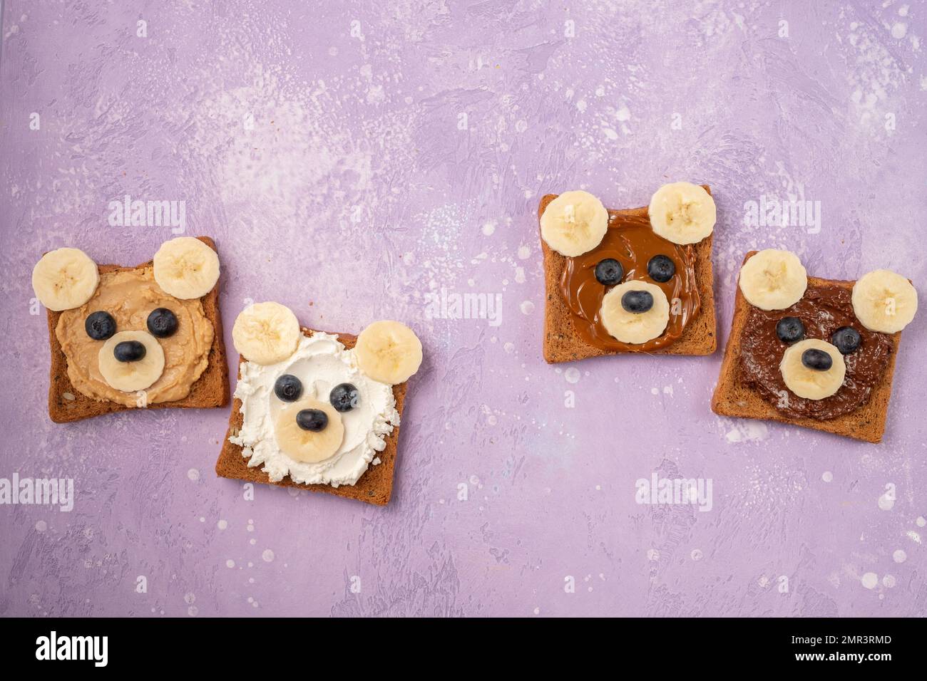 Breakfast toasts with nut butter and banana with cute funny bear face ...