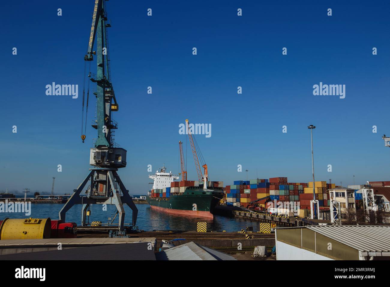 Loading of containers into cargo ship in the harbor Stock Photo - Alamy