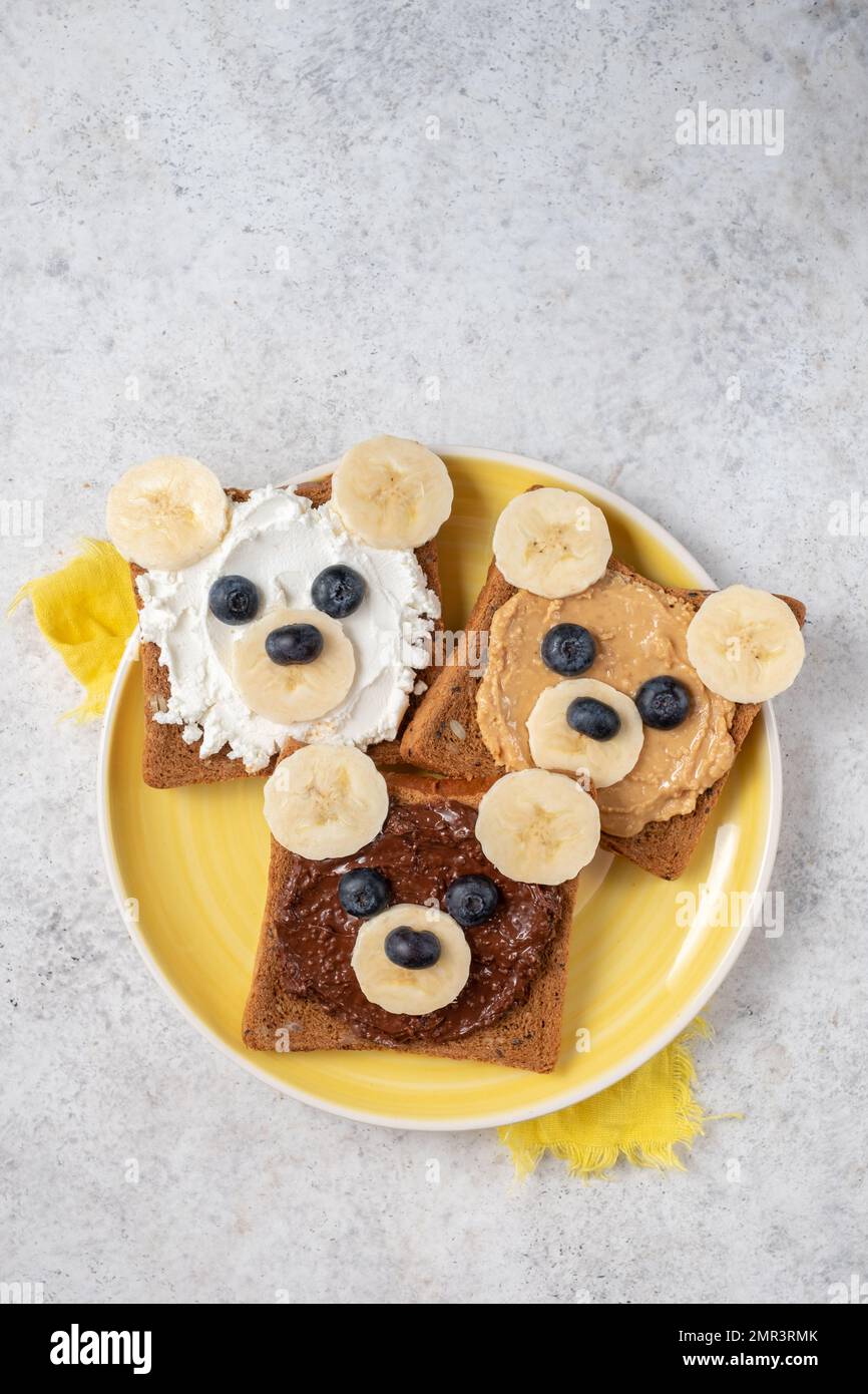Breakfast toasts with nut butter and banana with cute funny bear face ...