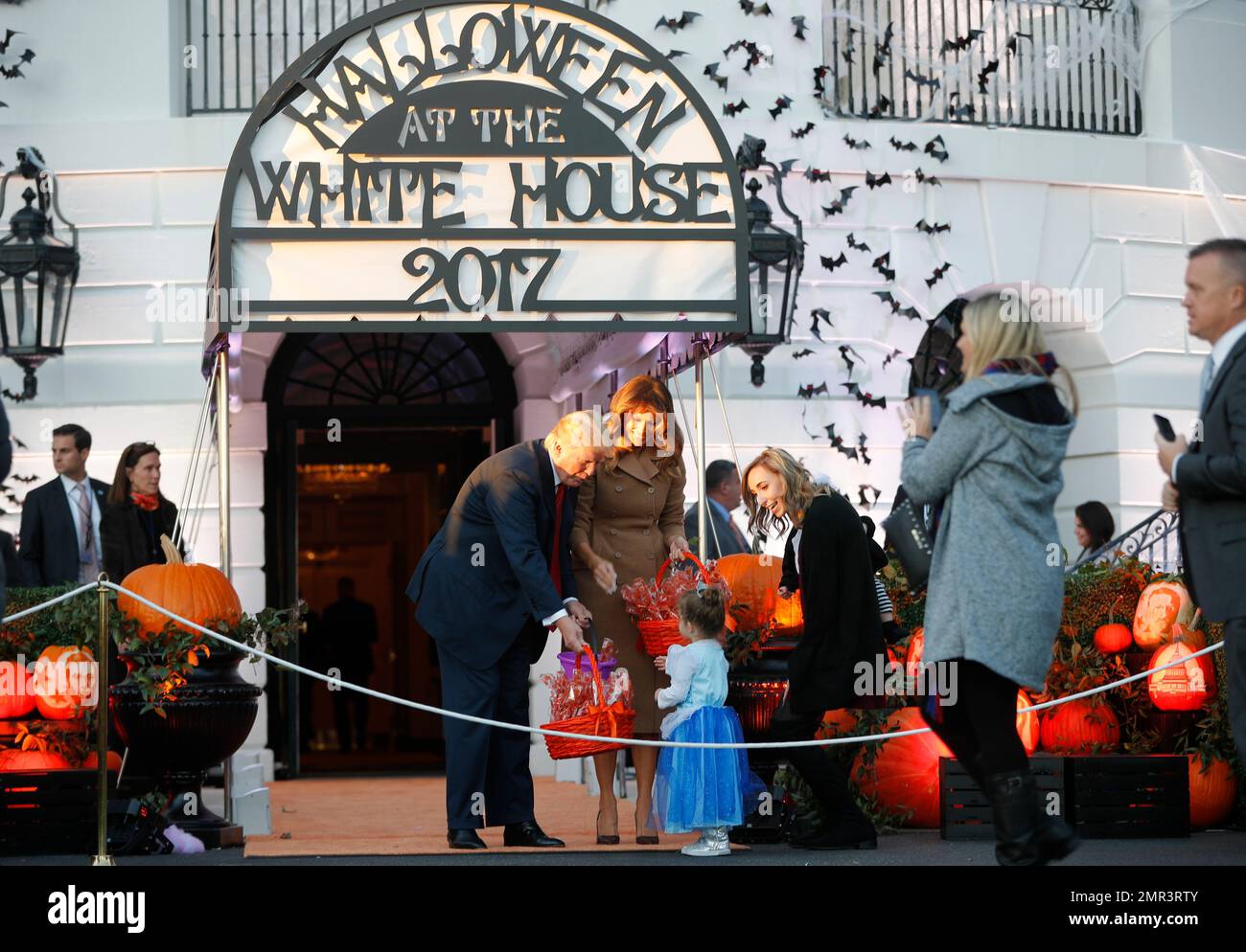 President Donald Trump and first lady Melania Trump hand out treats as ...